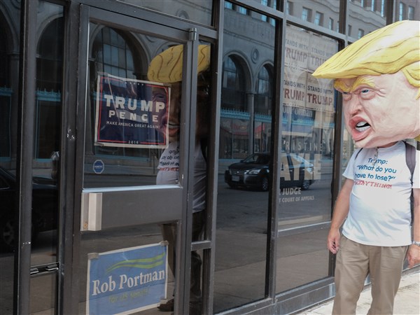 Man in giant paper-mache Trump head touring downtown Toledo streets ...
